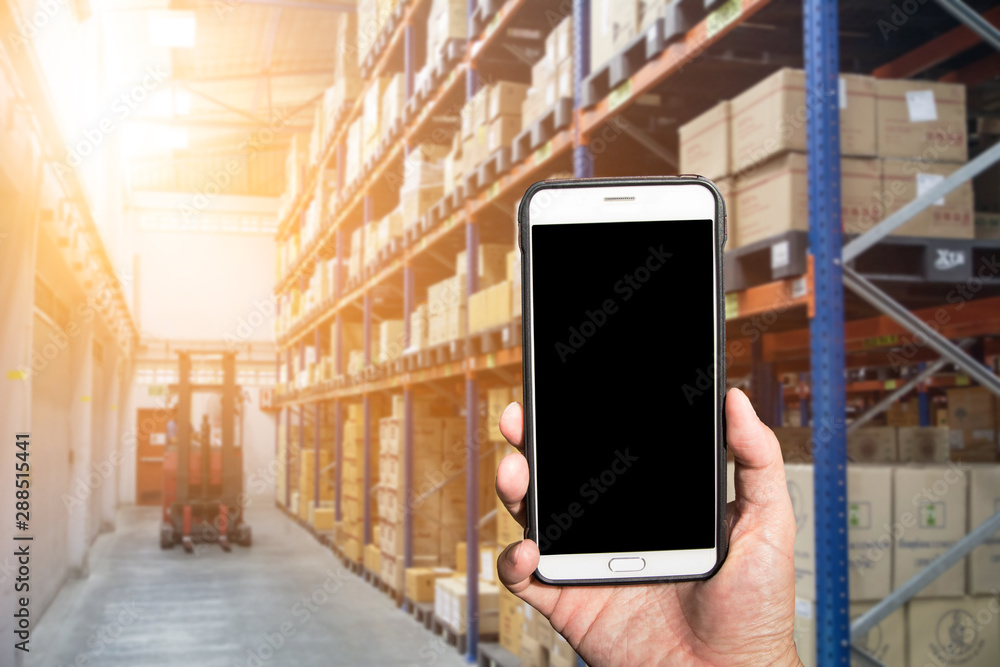 Hand holding a smartphone with black screen at warehouse, Concept for ...