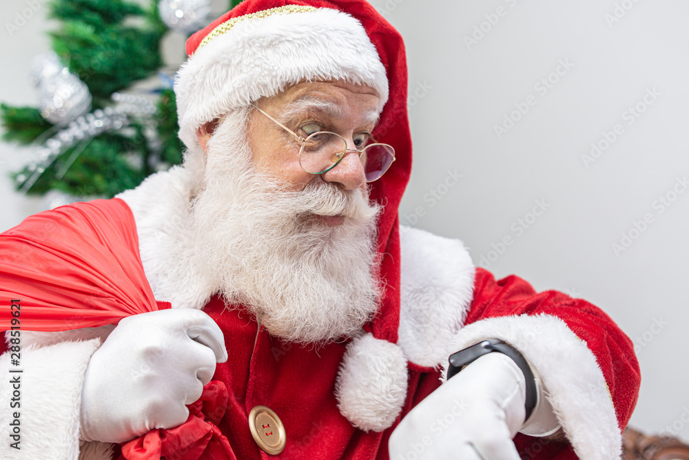 Santa Claus is late. He looks scared at the clock. Santa Claus wears a ...