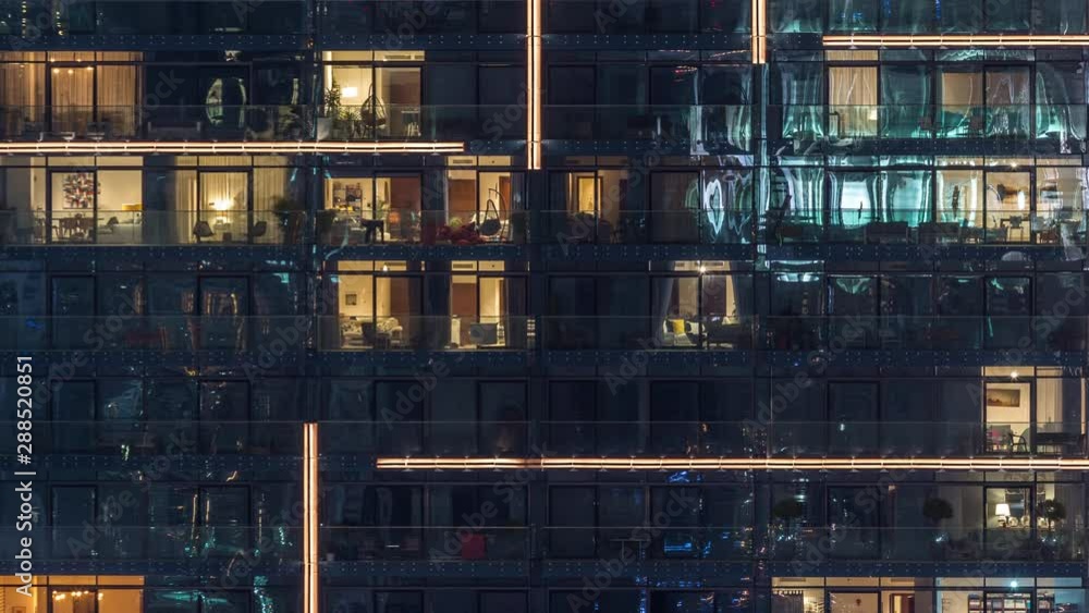 Lights in windows of modern multiple story building in urban setting at ...