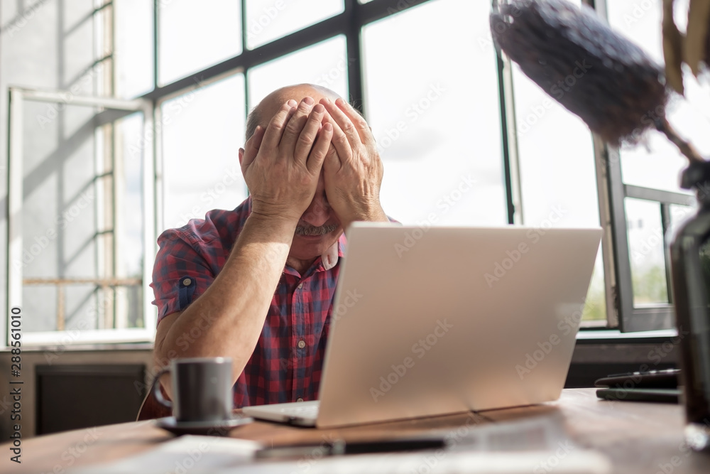 Senior caucasian man rubbing his tired eyes. He is tired to look on ...