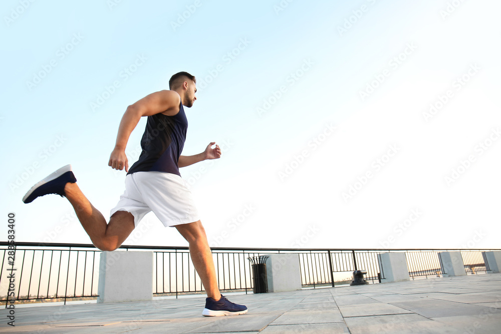 Handsome sporty man running outdoors Stock Photo | Adobe Stock