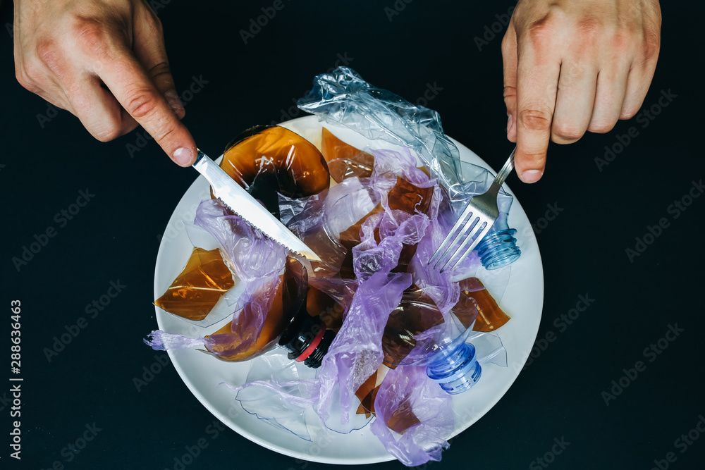 Plastic bottles on the plate. People eating polluted food ...