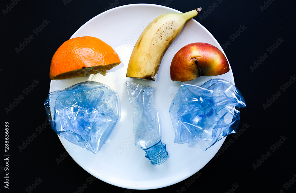 Plastic bottles and fruit on the plate. Life choice. People eating ...