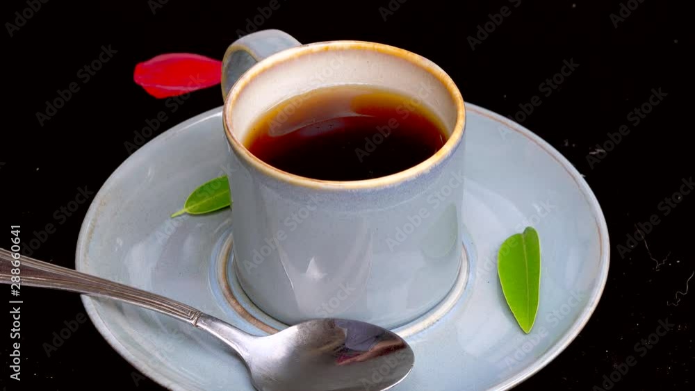 4k video Taking a sip from a blue coffee cup with a spoon on black ...