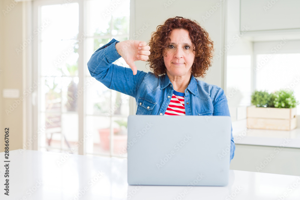 Senior woman working using computer laptop with angry face, negative ...