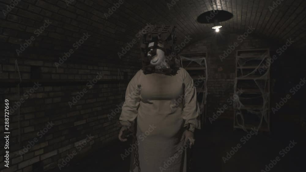 A scary ghost of a fat woman with a rusty cage on his head and with ...
