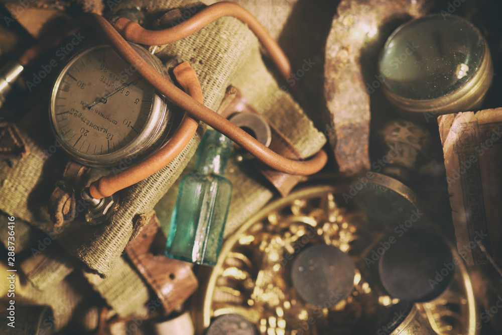 Different antique items on the table: bronze jewelry, old money, retro ...