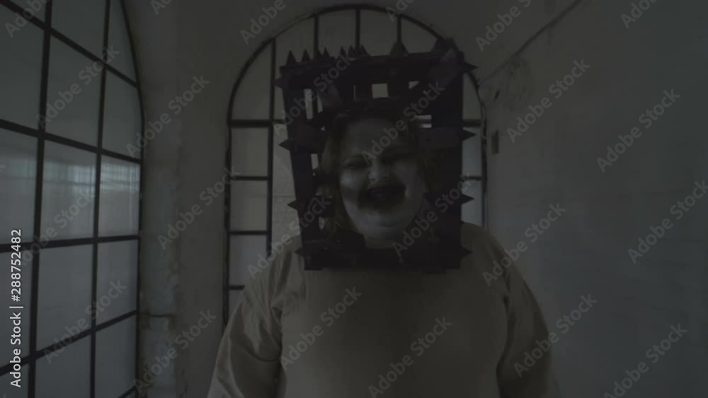 A scary ghost of a fat woman with a rusty cage on his head and with ...