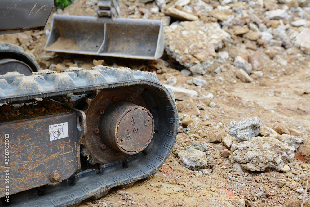 Rubber track of a digger against concrete and earth debris foto de ...