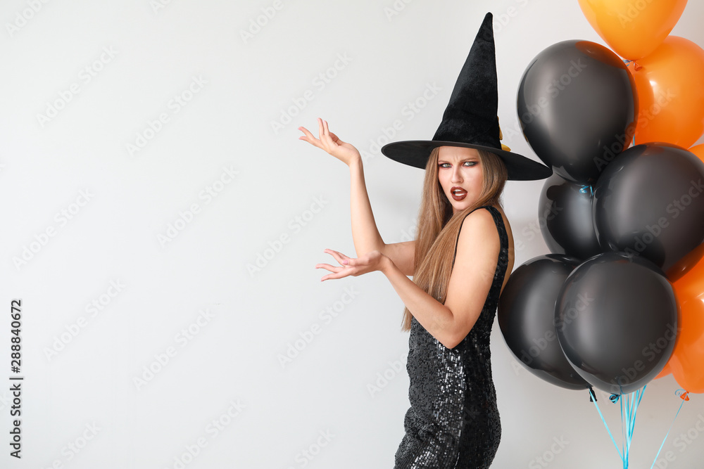 Beautiful woman dressed as witch for Halloween on light background ...