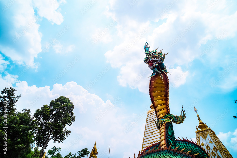 Beautiful green naga or serpent statue with blue sky and clouds ...