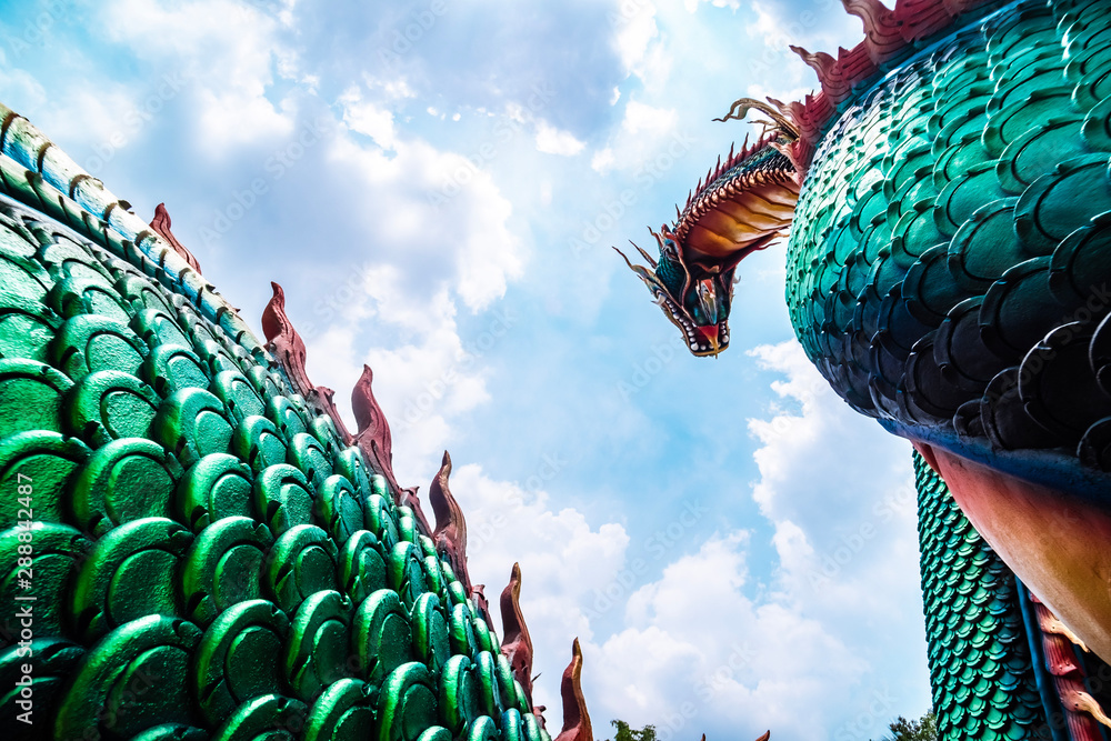 Beautiful green naga or serpent statue with blue sky and clouds ...