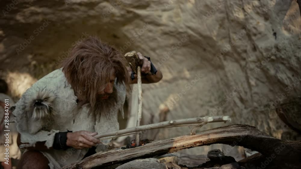 Primeval Caveman Wearing Animal Skin Trying to make Fire with Bow Drill ...
