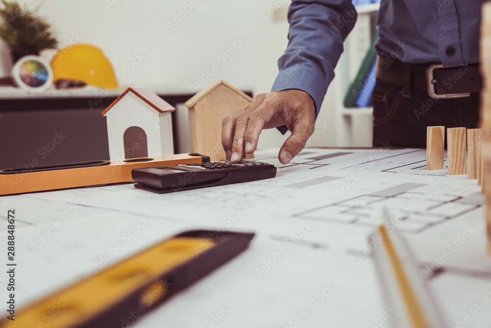 Architect Engineer using calculator Estimate construction drawings with ...