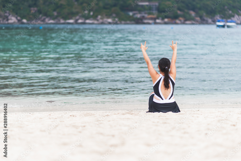 Asian girl sitting by the beach, symbolizing hand, showing love for the ...