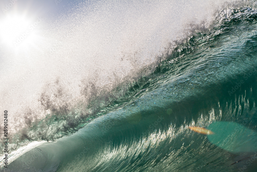 Huge flaring wave breaking close up with lens flare from the sun Stock ...