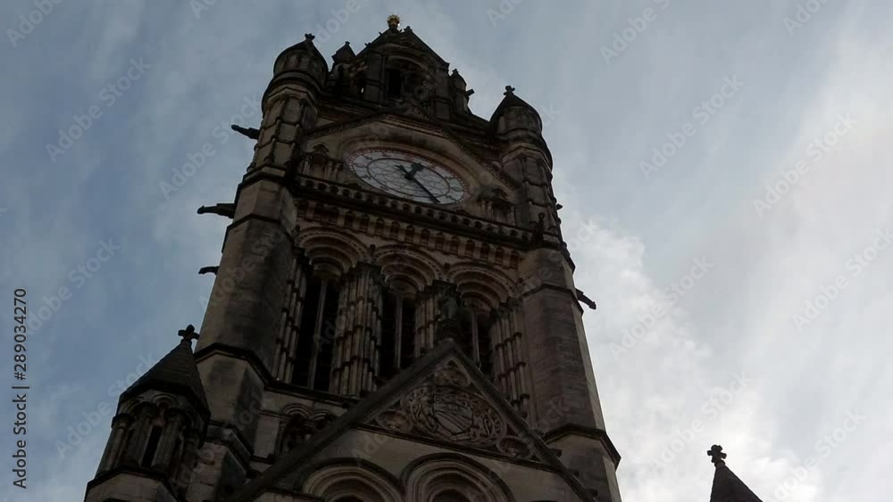 Manchester town hall clock face tower, static shot a clouds pass behind ...