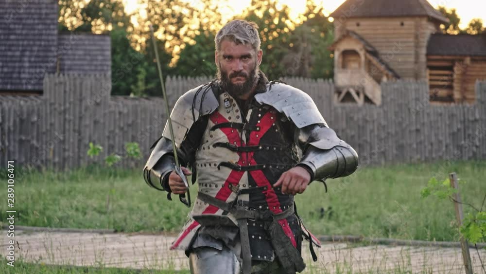 Angry knight going on camera and brandish with sword. Close-up of ...