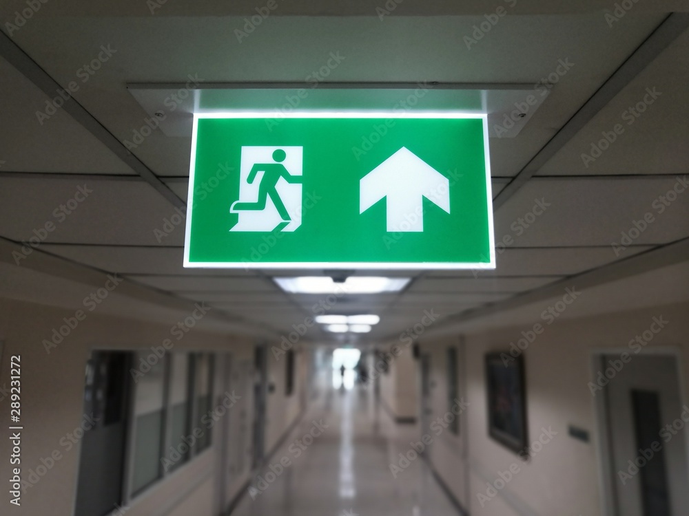 Emergency Fire exit sign hanging on top of the building in modern ...