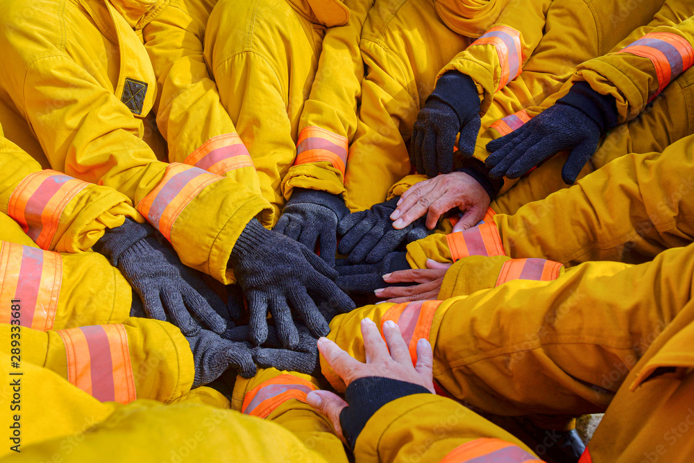 Firefighters team in uniform. Members of the fireman clash their hands ...