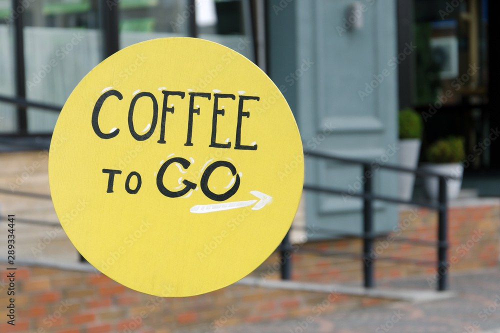 yellow retro outdoor sign coffee to go in the morning on the street ...