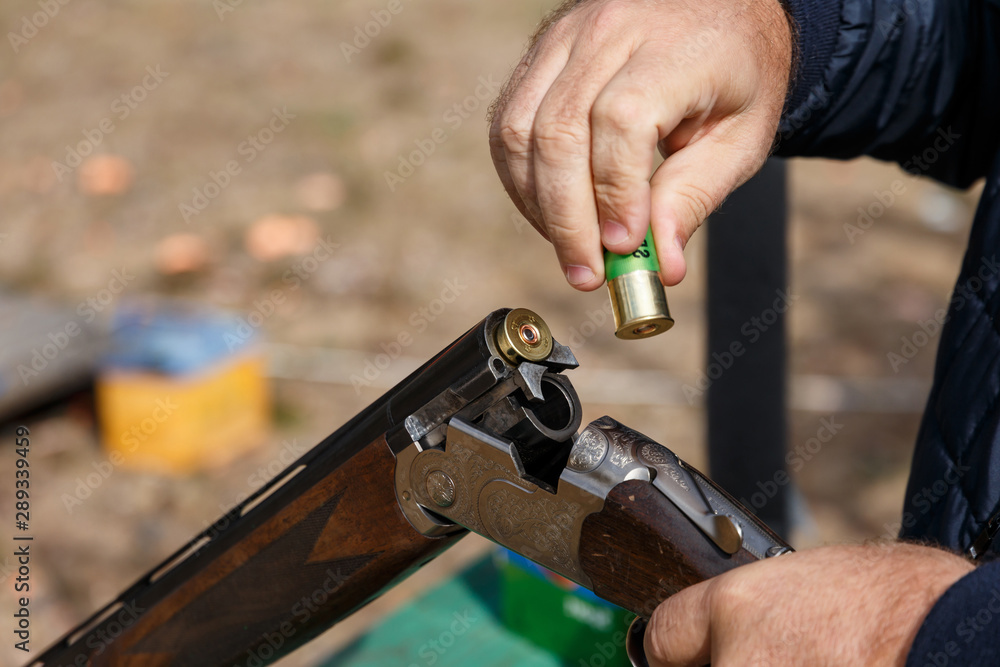 Charging a hunting rifle. Male hunter charges a double-barreled shotgun ...