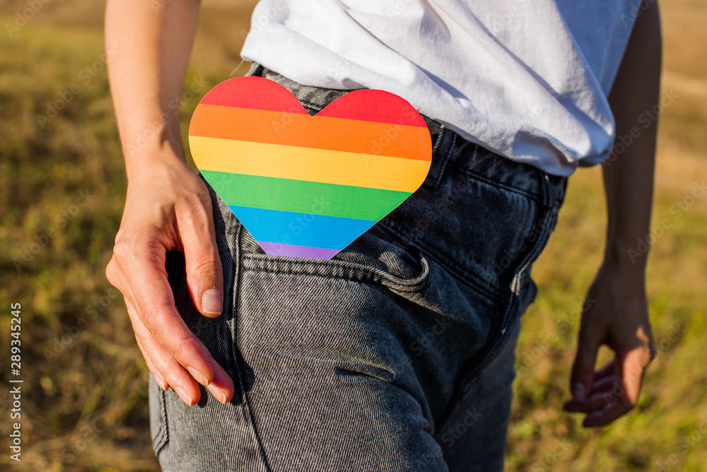 Woman holds in hands a heart in the colors of the rainbow. Young ...