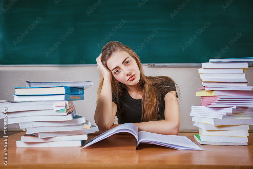 Frustrated female student sitting at the desk with a huge pile of study ...