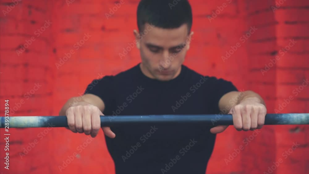 The rider stands with a very heavy bar on his shoulders. He is at the ...