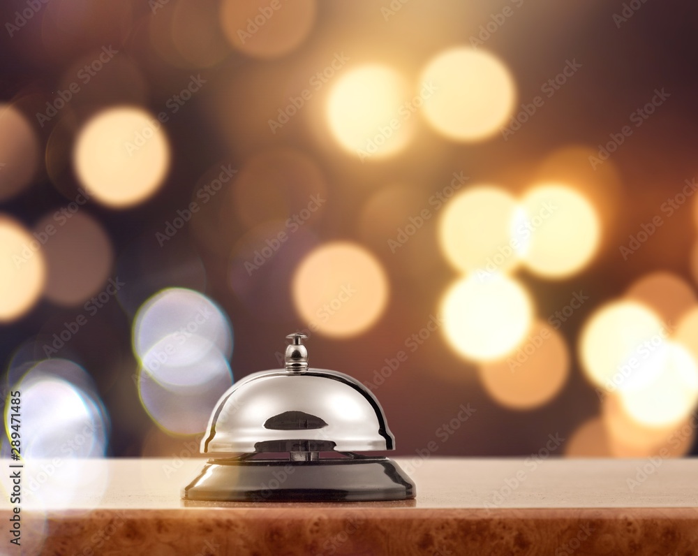 Vintage hotel reception service desk bell on blurred background, bokeh ...
