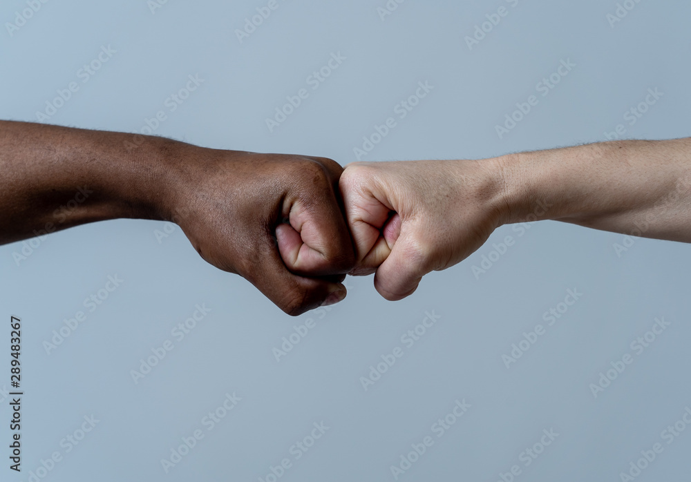 Fist of different skin colors giving fist bump. Conceptual image of ...
