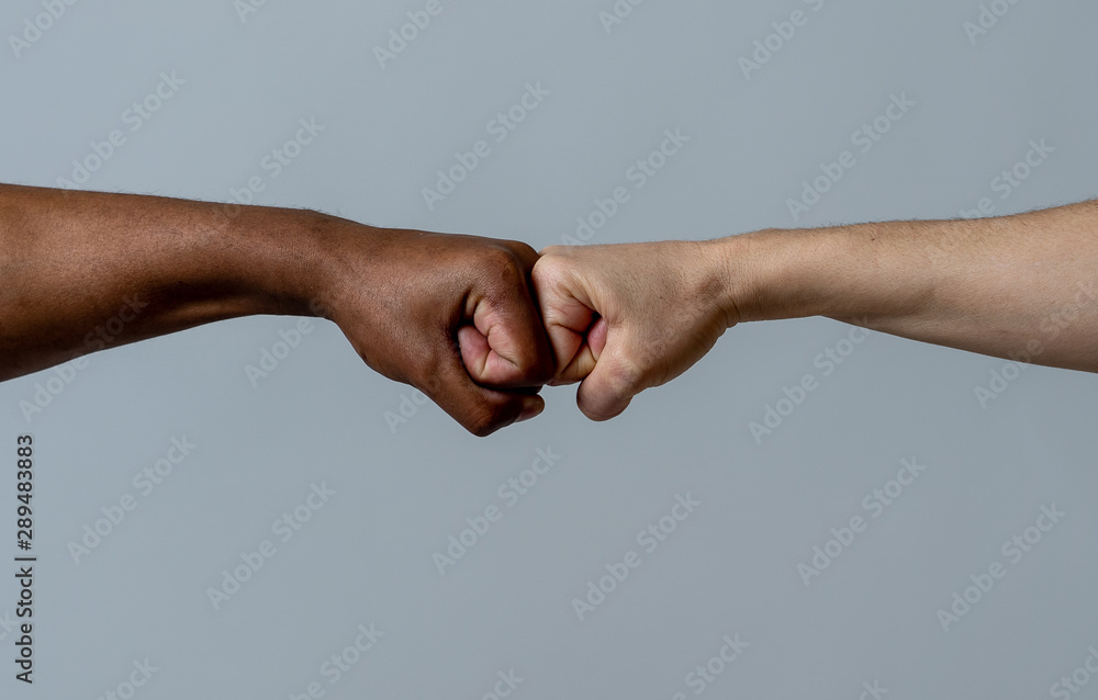 Fist of different skin colors giving fist bump. Conceptual image of ...
