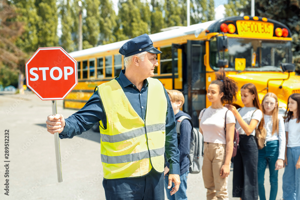 Group of children going out the school bus ready to cross the road ...