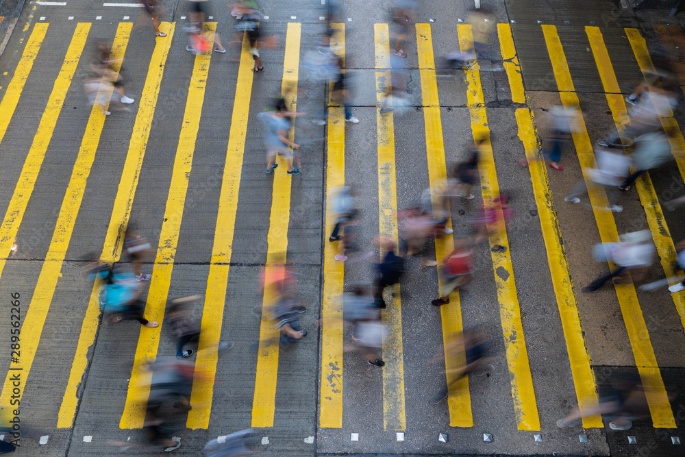 Aerial top view of crowd of people walking on street over zebra ...