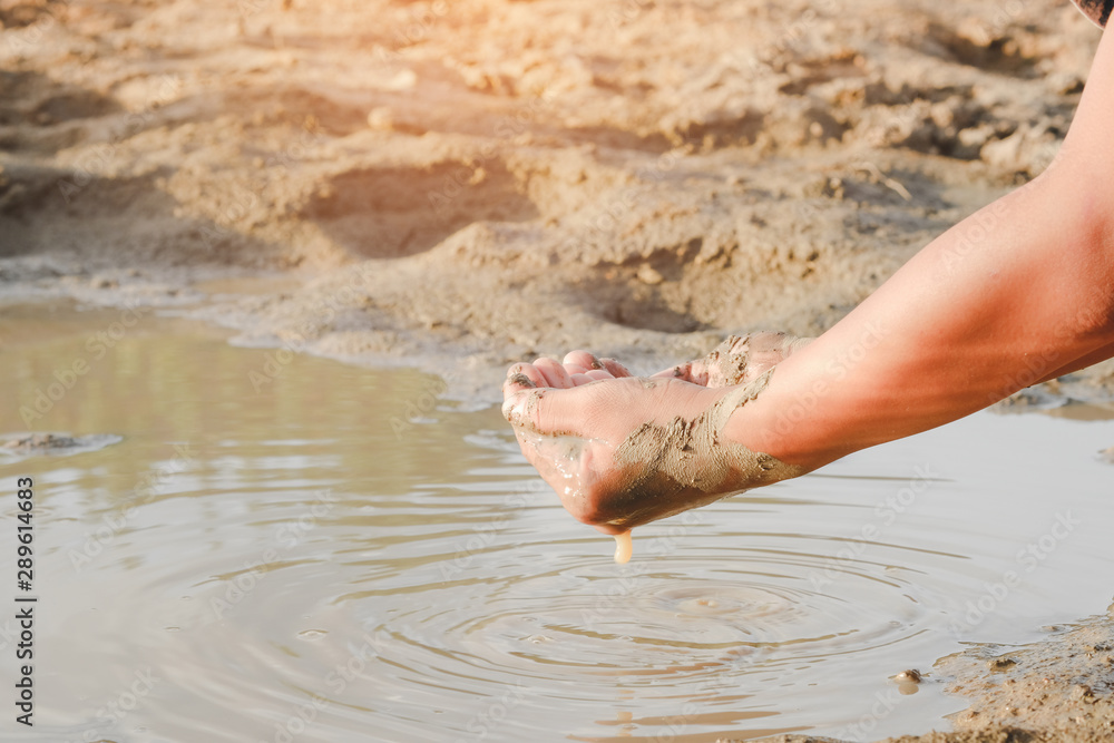 Drops of water falling from kid hand on Crack dried soil background ...