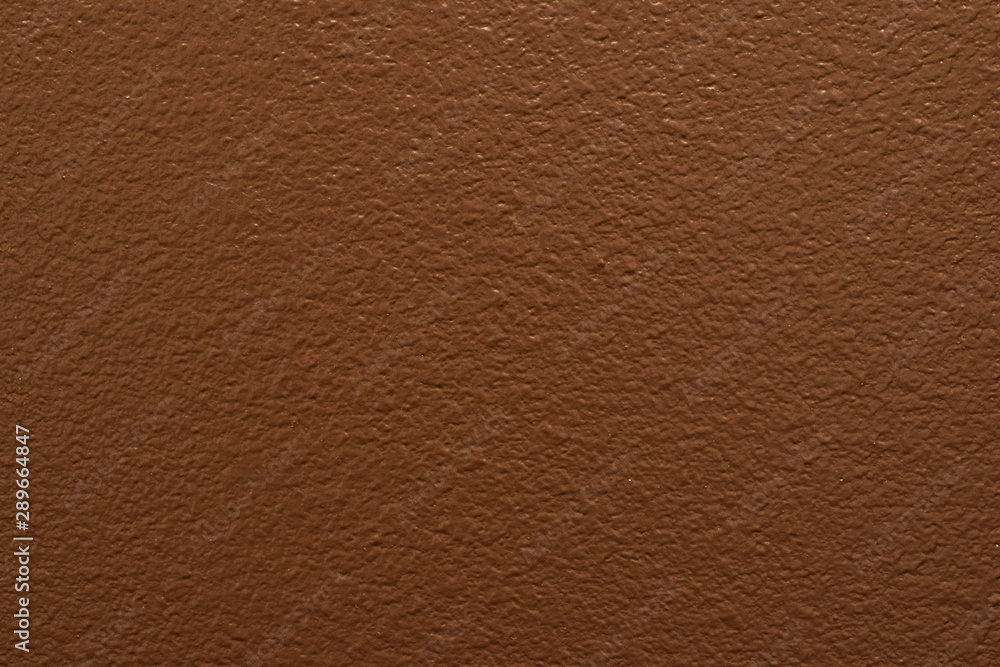 Color swatch of brown paint on a section of drywall with light textures ...