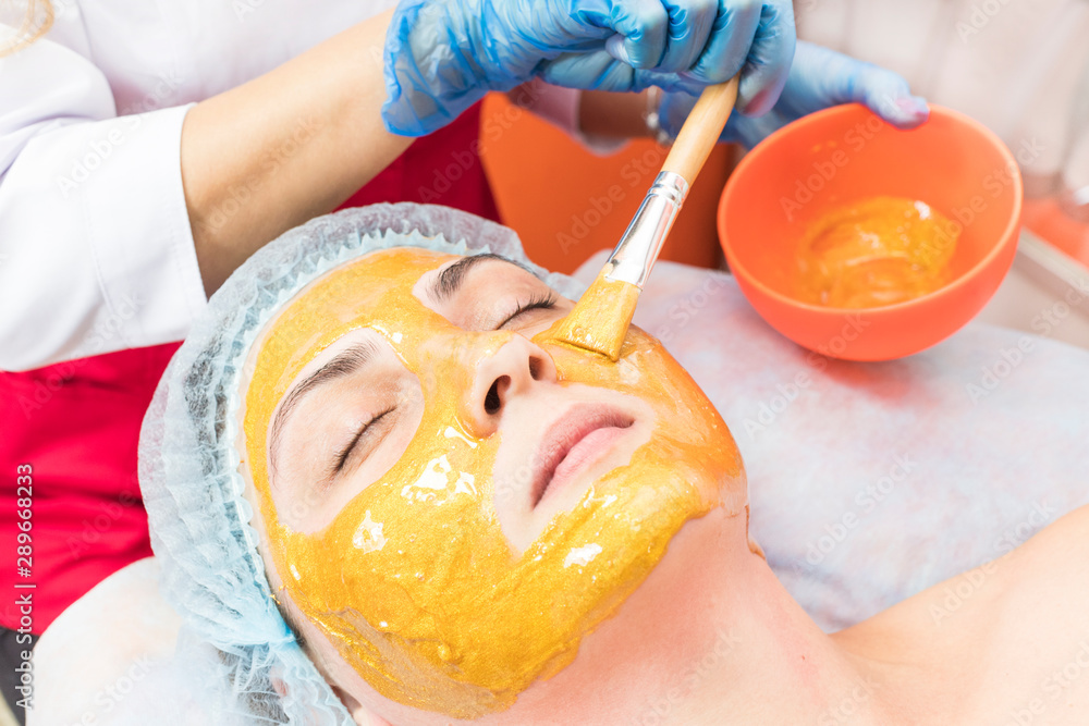 The procedure in the beauty salon applying a personal mask on the face ...