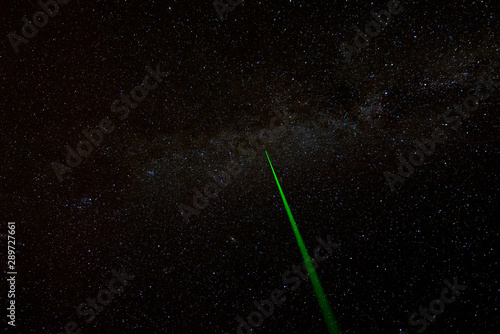Plakat A laser beam shoots into the night sky. Part of the Milky Way ...