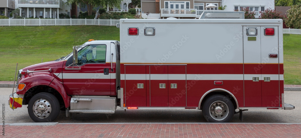 Front side view of red and white ambulance parked on residential street ...