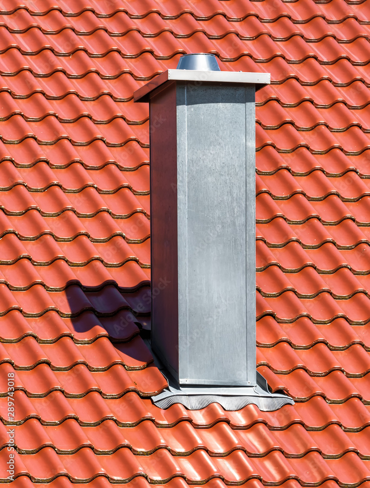 Chimney on clean roof of residential house. Modern air vent system on ...