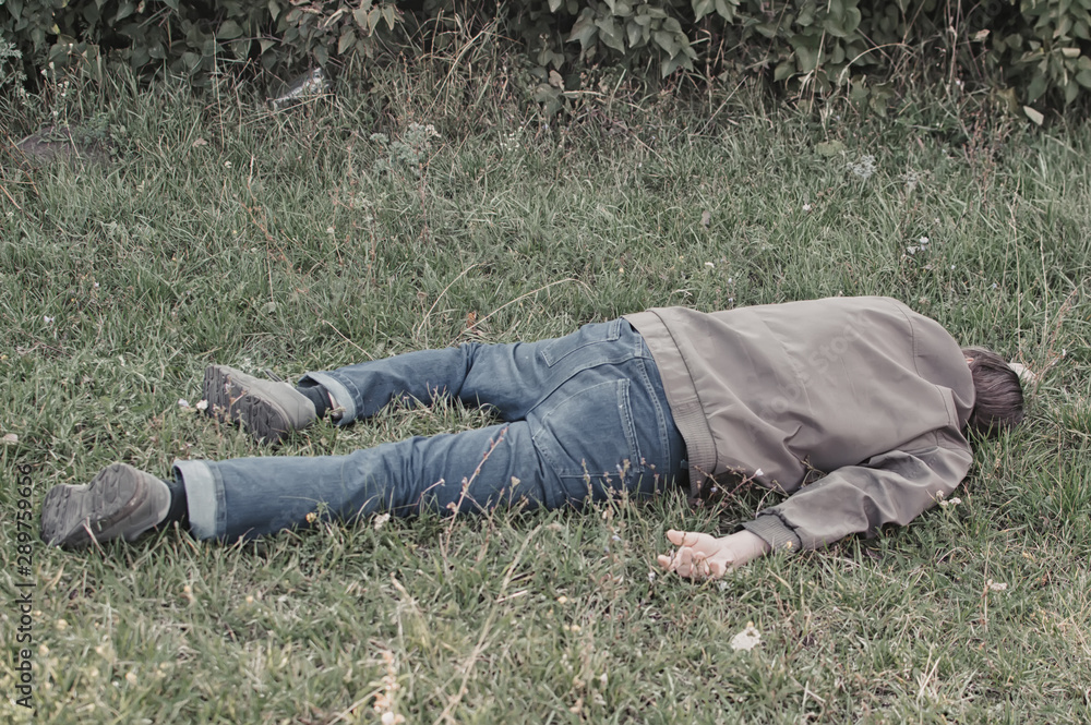 The corpse of a tramp in the grass. Criminal. Alcoholic intoxication ...