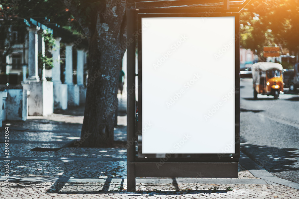 An urban bus stop with an empty poster mock-up; template of an ...