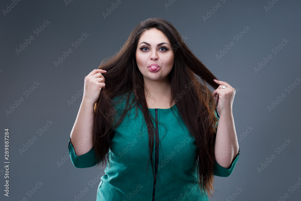 Happy plus size fashion model in green dress, fat woman shows tongue on ...