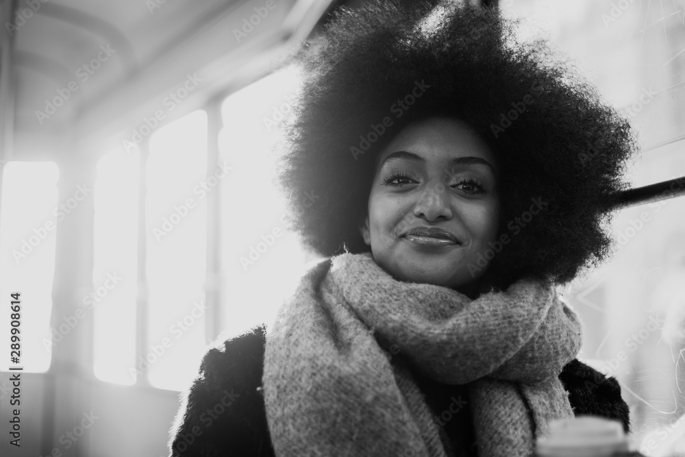Beautiful girl with afro haircut portraits in the public transport ...