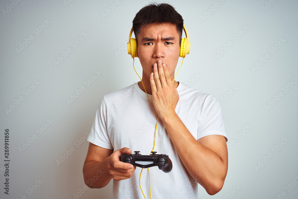 Young asian chinese gamer man playing video game standing over isolated ...