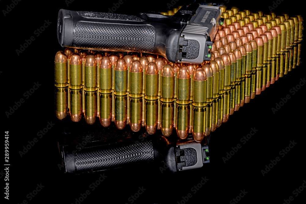 Semi-Automatic Handgun on rows of ammo, ammunition with black ...