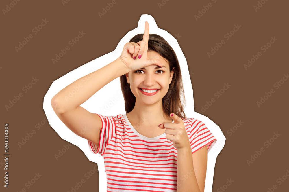 a happy woman gives a sign of the loser on his forehead, looking at you ...