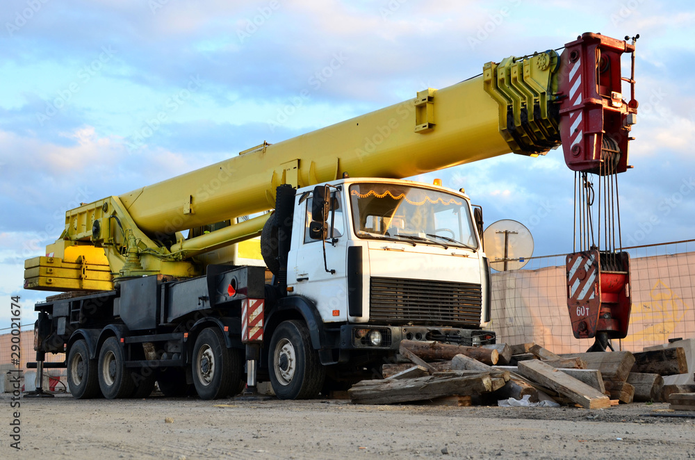 Unloading of cargo and building materials by mobile truck crane at the ...