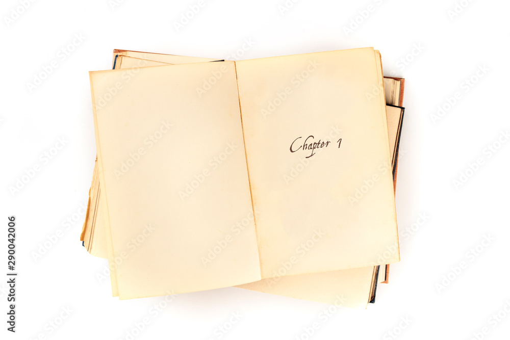 First Chapter, yellow pages of an open old book on a pile of others ...