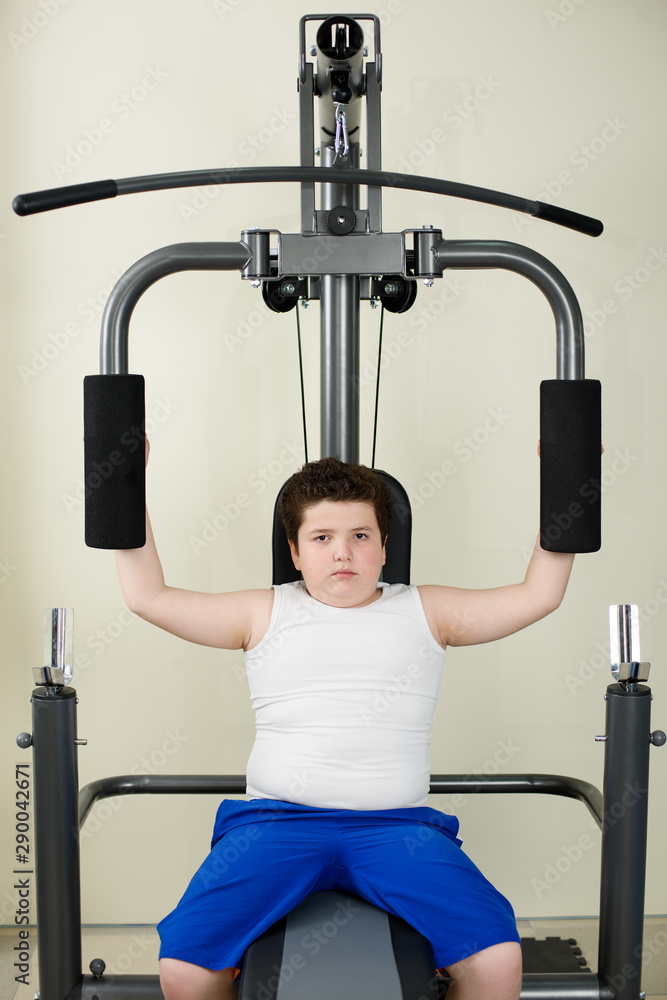 strong overweight little caucasian boy sitting on fitness equipment in ...